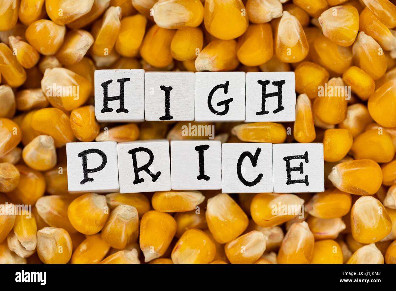 The wording "High Price" composed on the background of bulk corn grain ...