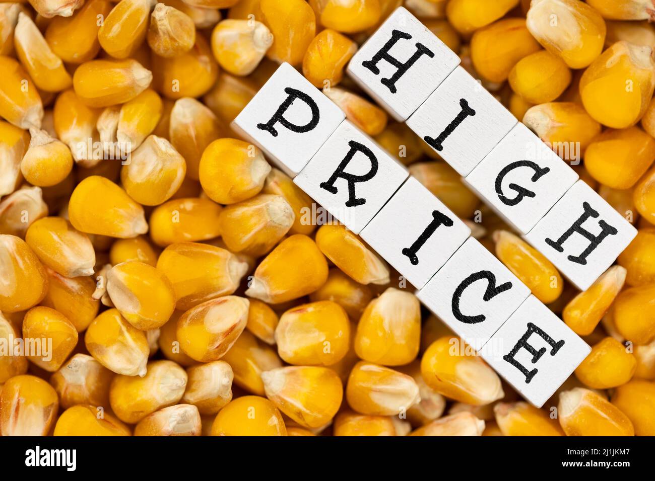 The wording "High Price" composed on the background of bulk corn grain ...