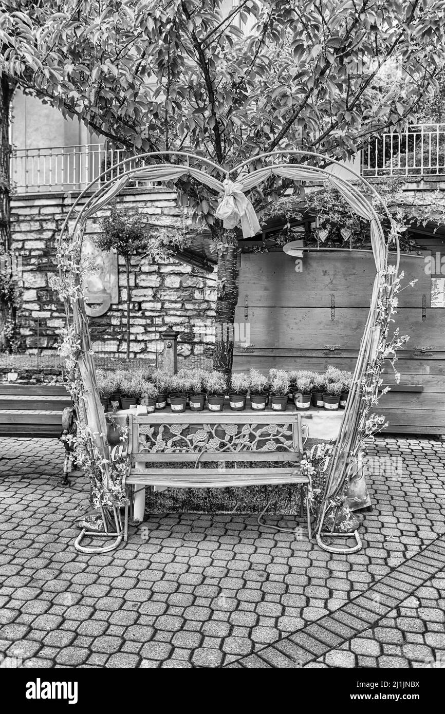 Scenic heart-shaped bench decorated with flowers and laces. Love ...