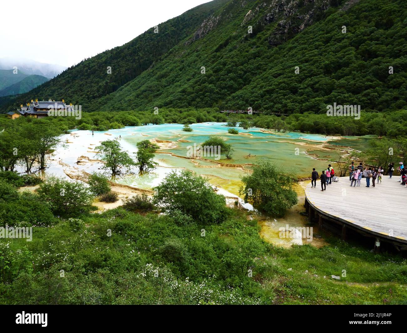 The tourists admiring the beauty of a natural blue pool in Huanglong ...