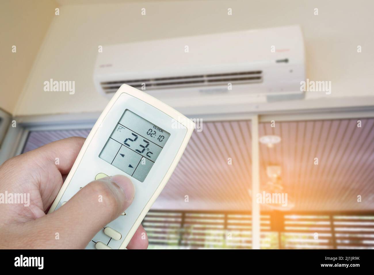 Hand hold remote control with conditioner background Stock Photo - Alamy