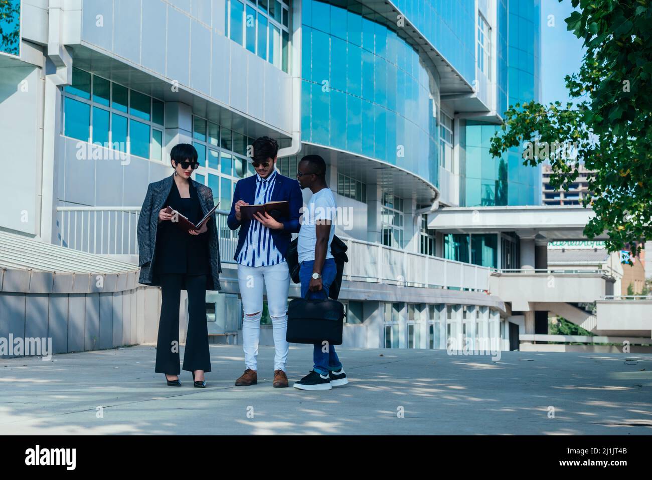 Businessman showing documents to his multi-ethnic co-workers in front ...