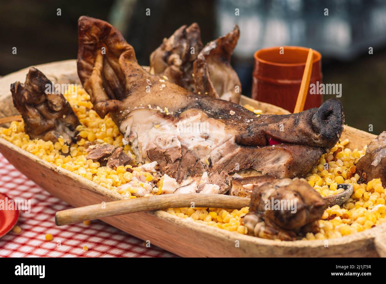 Grilled meat pork head in a wooden traditional plate on a table in a ...