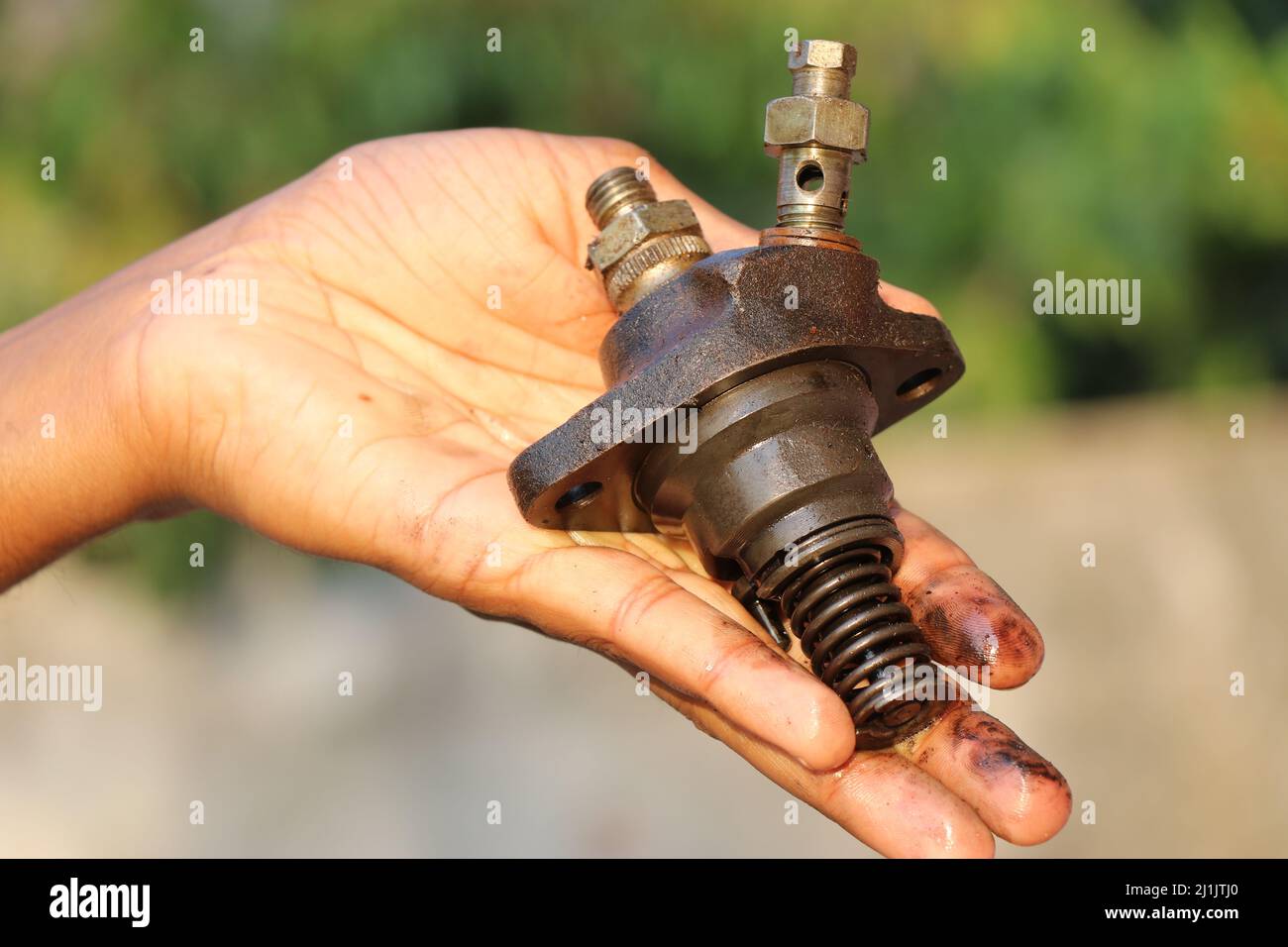 Diesel Fuel injector from an old diesel engine held in hand with a view ...