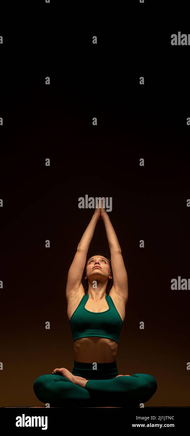 Attractive and beautiful young girl is doing the lotus position on the ...
