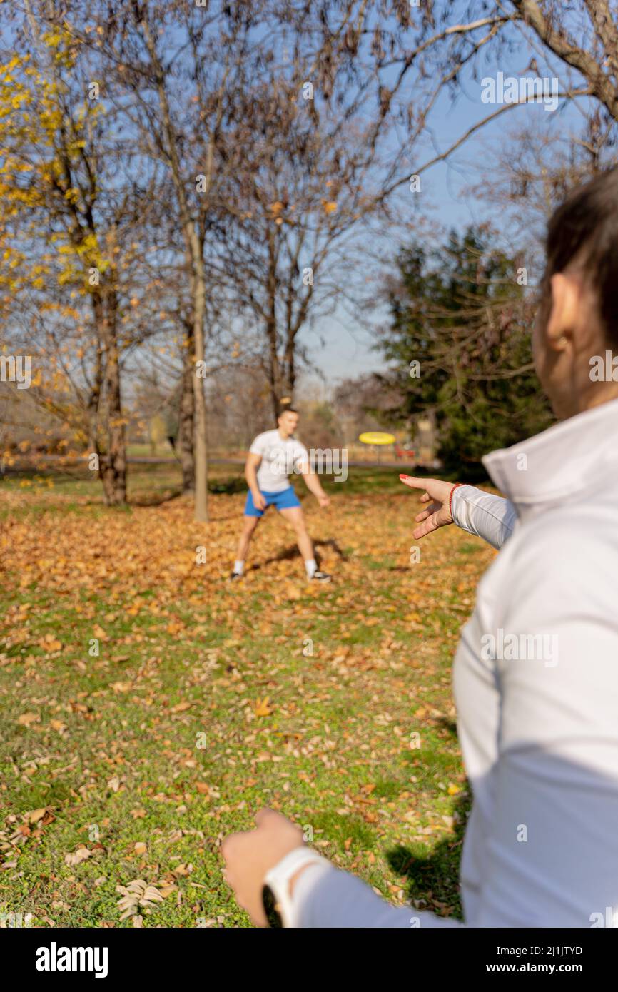 Two attractive and amazing fit friends are playing frisbee outside ...