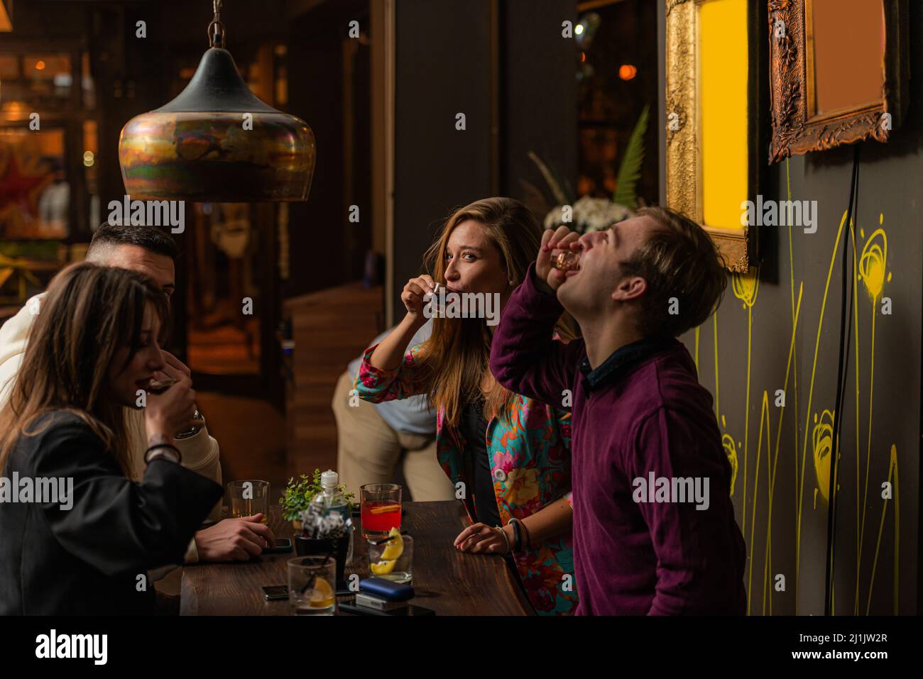 Two amazing and attractive couples are drinking shots together Stock ...