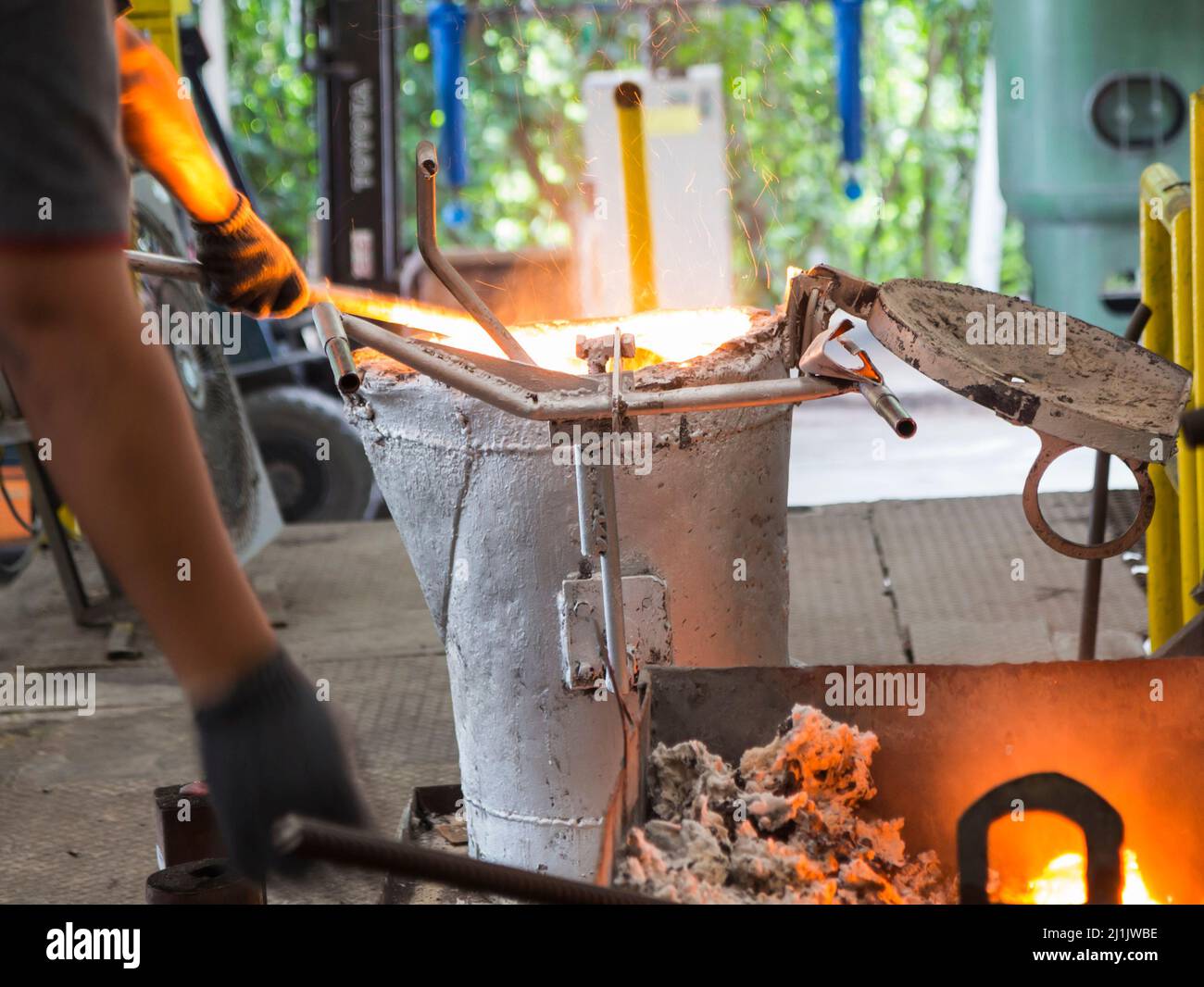 iron metal in laddle removing slag by operator ; industrial background ...