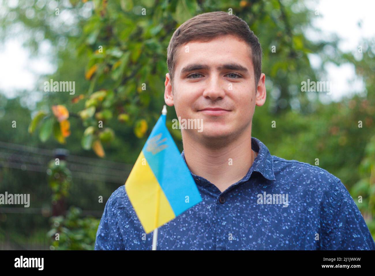 Ukrainian man. Young smiling man holding ukrainian flag. No war ...