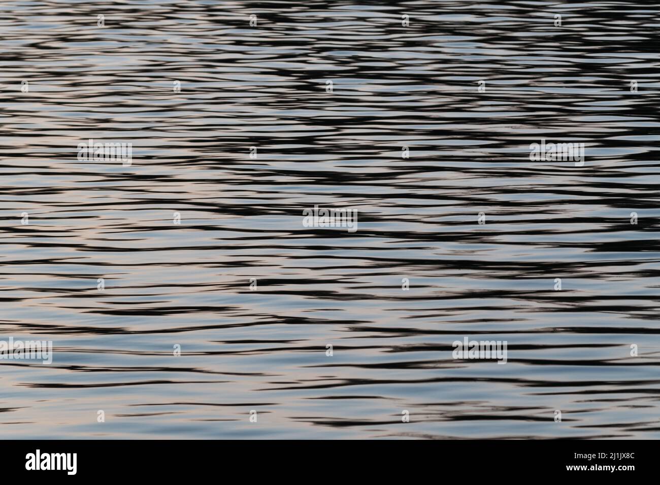 Abstract calm scene of water ripples on surface at dusk, nature detail ...