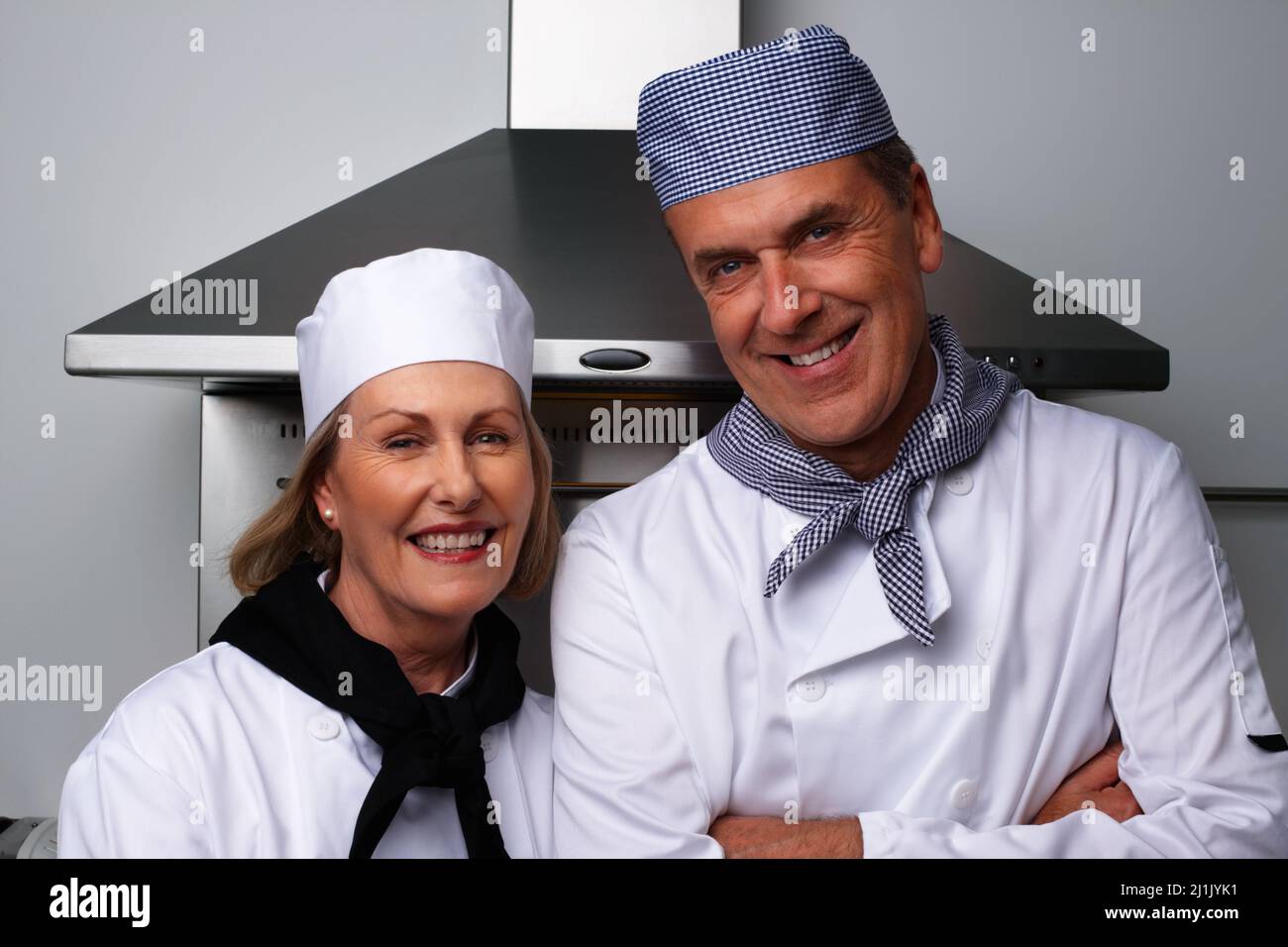 Smiling male and female chefs together standing in the kitchen ...