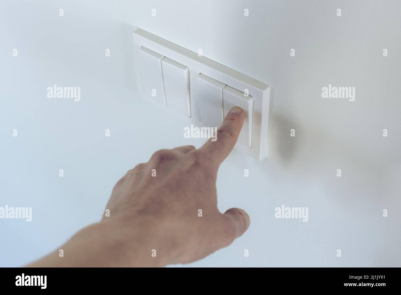 Hand presses a light switch with a finger Stock Photo - Alamy