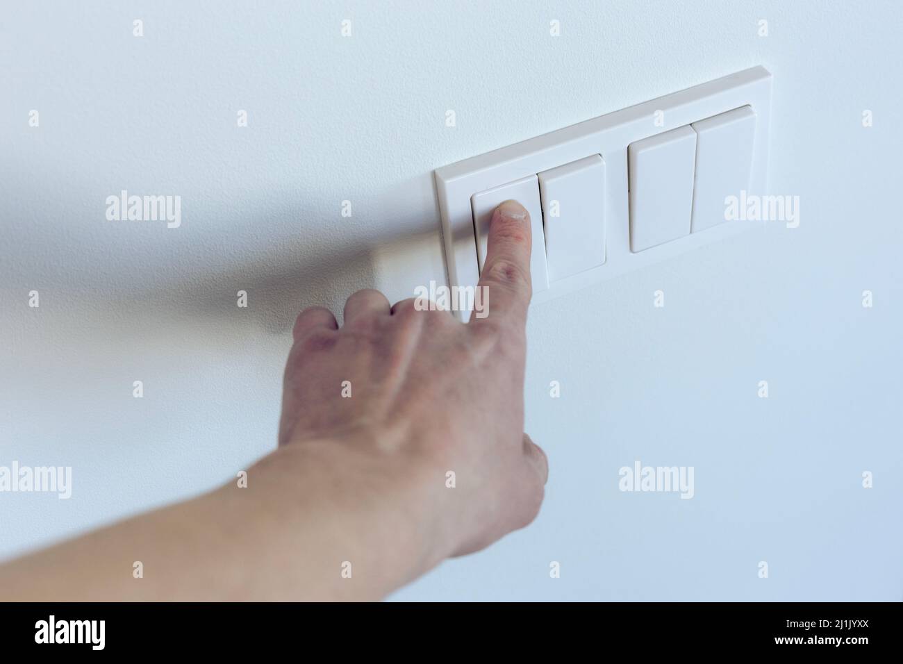 Hand presses a light switch with a finger Stock Photo - Alamy