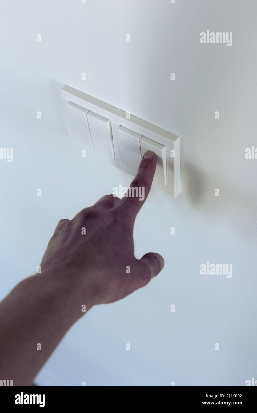 Hand presses a light switch with a finger Stock Photo - Alamy