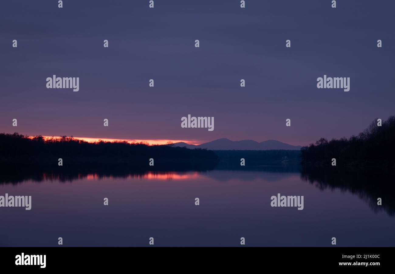 Calm nightfall over Sava river with fading light under clouds and ...
