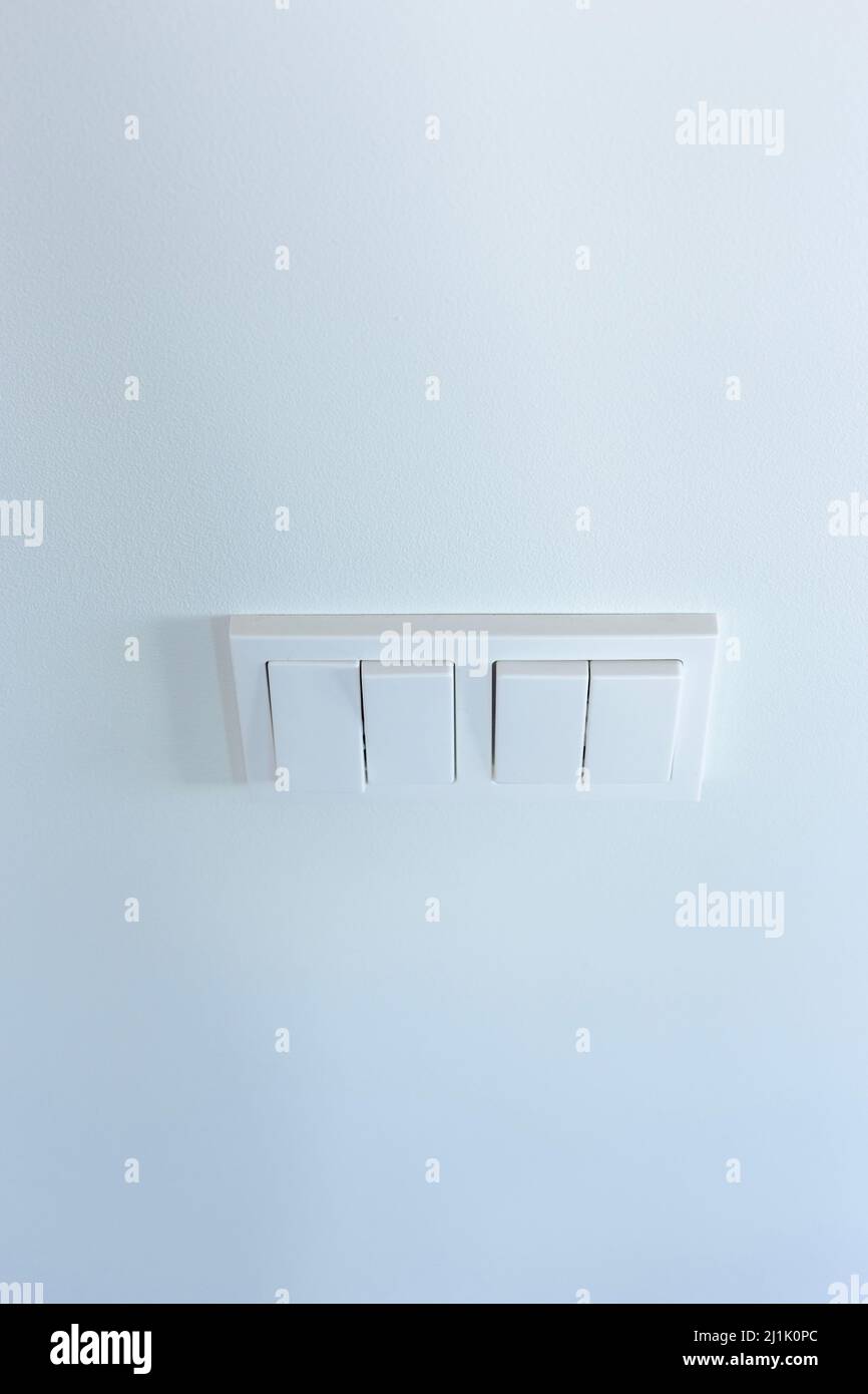White light switches on a white wall Stock Photo - Alamy