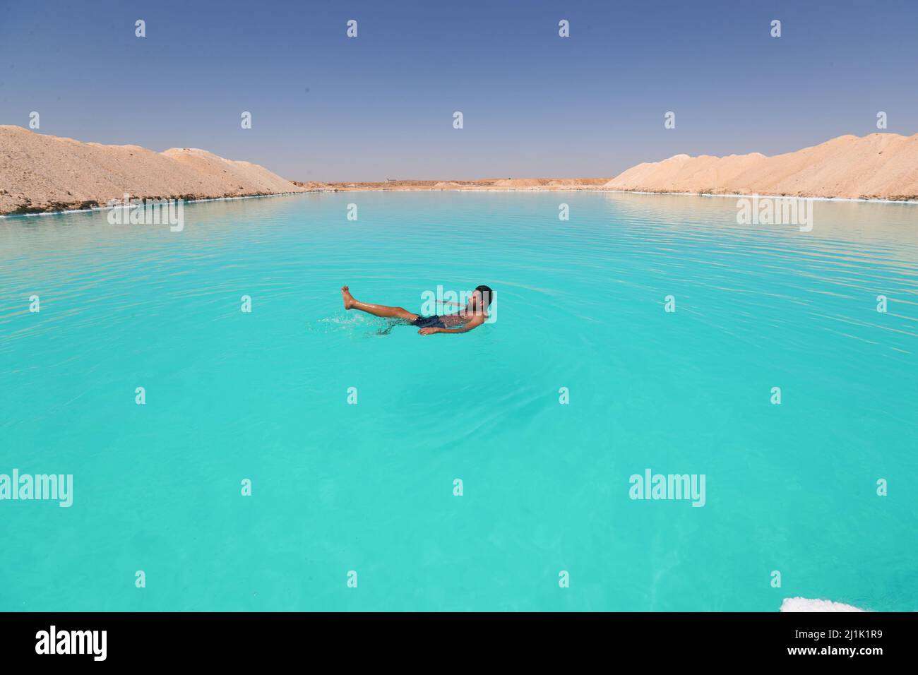 Siwa, Egypt. 26th Mar, 2022. A man floats on a salt lake at Siwa Oasis ...