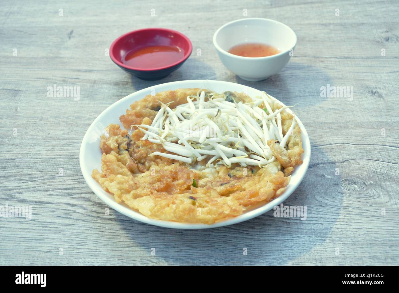 fried egg stuffed mussel with bean sprout on plate dipping sweet and ...