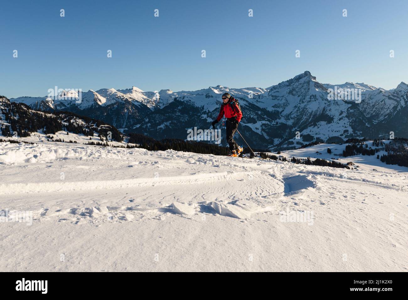 Ski tourist in the afternoon sun in front of the panorama of the Glarus ...