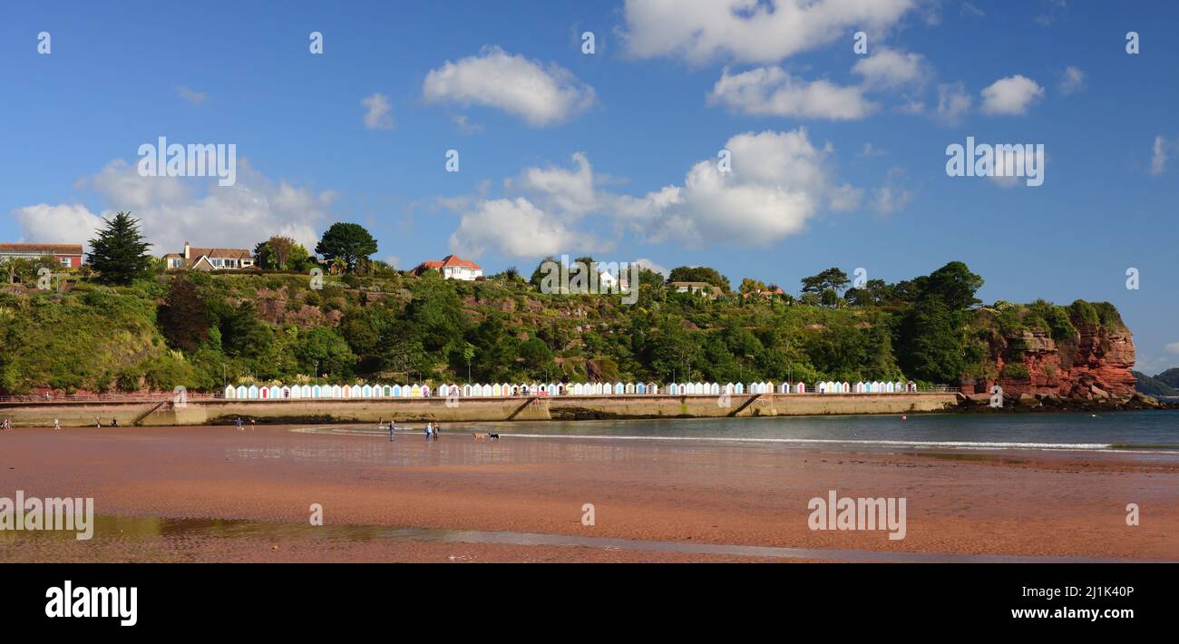 Beach huts beneath Roundham Head and low tide on the beach at ...