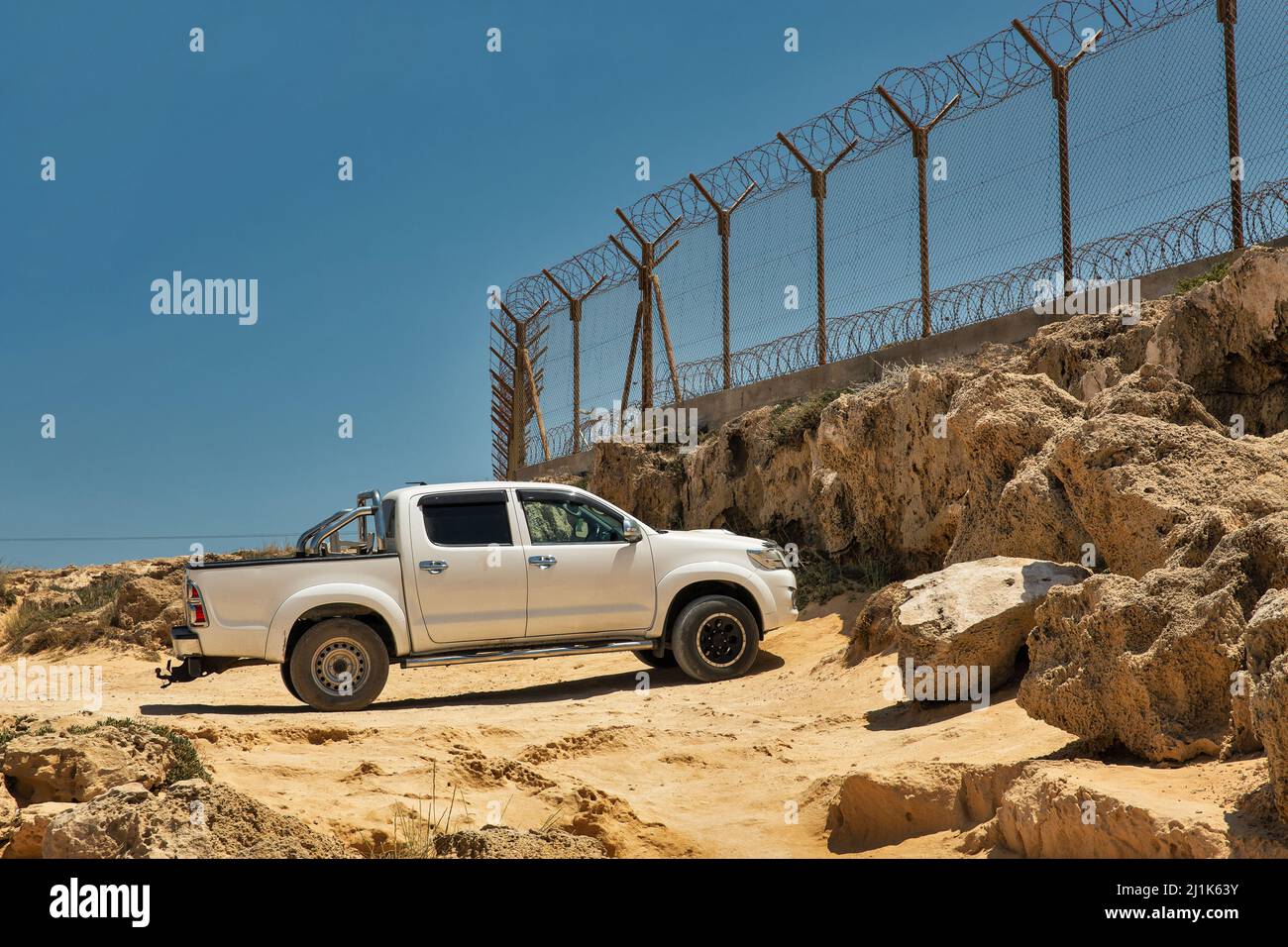 Military base with barbed wire fence and pikup car Stock Photo - Alamy