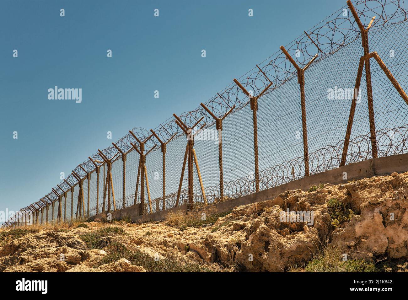Military base with barbed wire fence closeup Stock Photo - Alamy