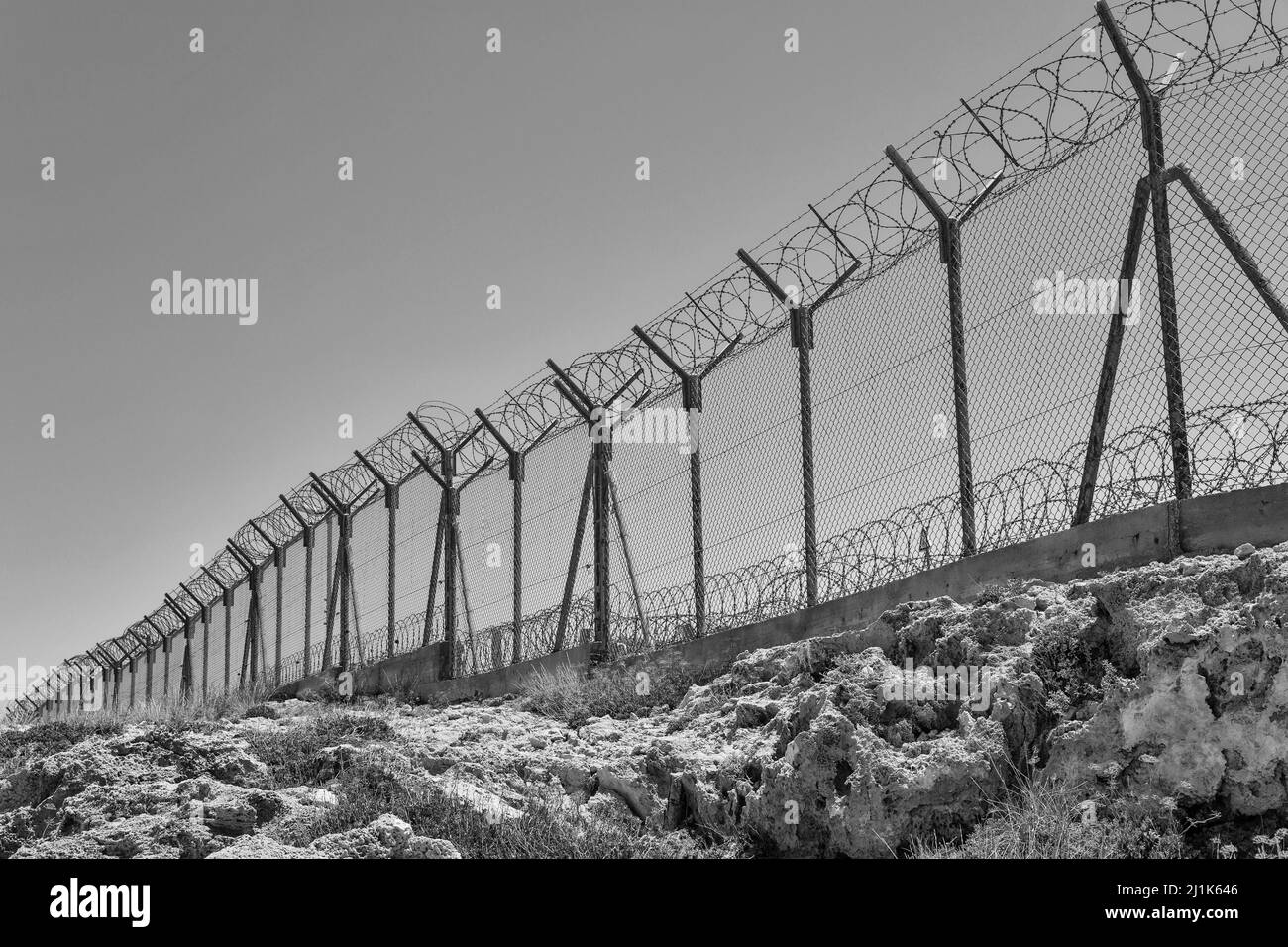 Military base with barbed wire fence closeup. Black and white Stock ...