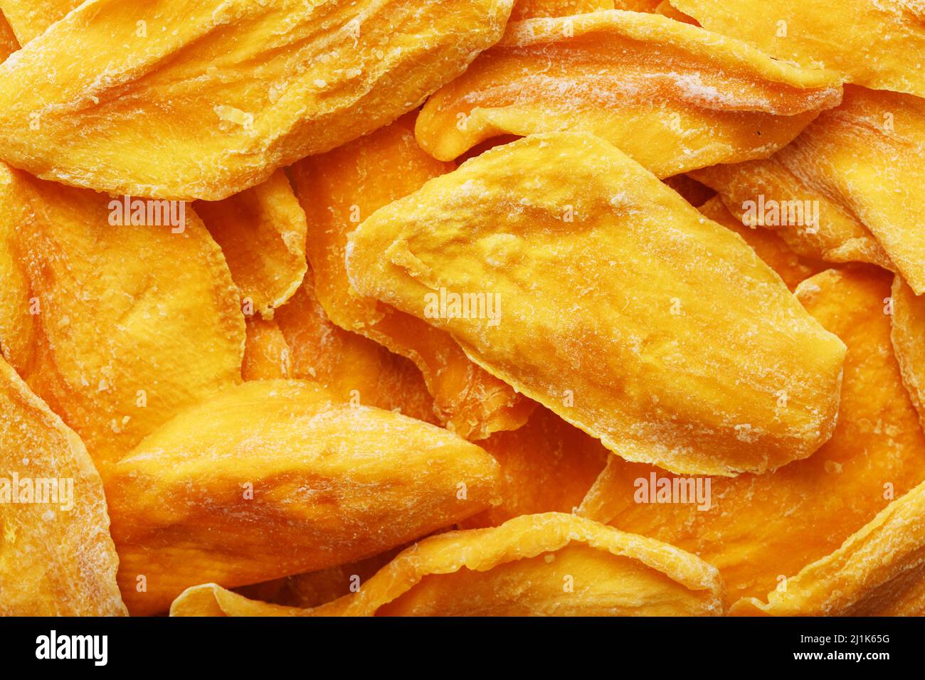 Pieces of sweet dried mango close-up as a background in full screen top ...