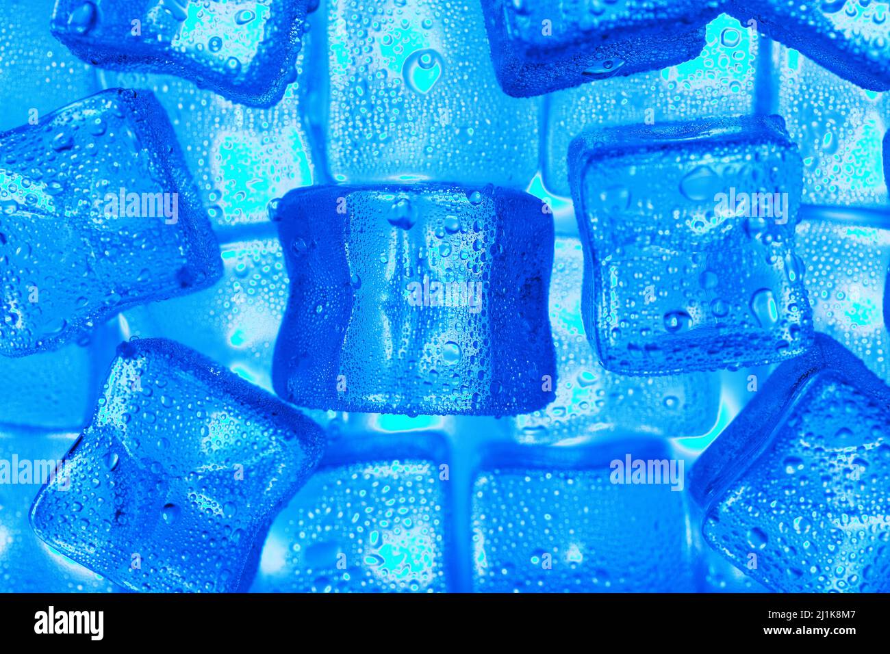Ice cubes with blue backlight in the freezer close-up in full screen ...
