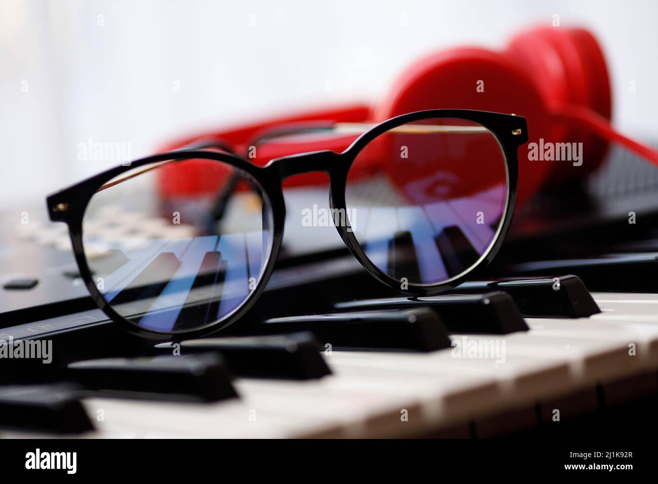 Red headphones and eyeglasses on the synthesizer keyboard Stock Photo ...