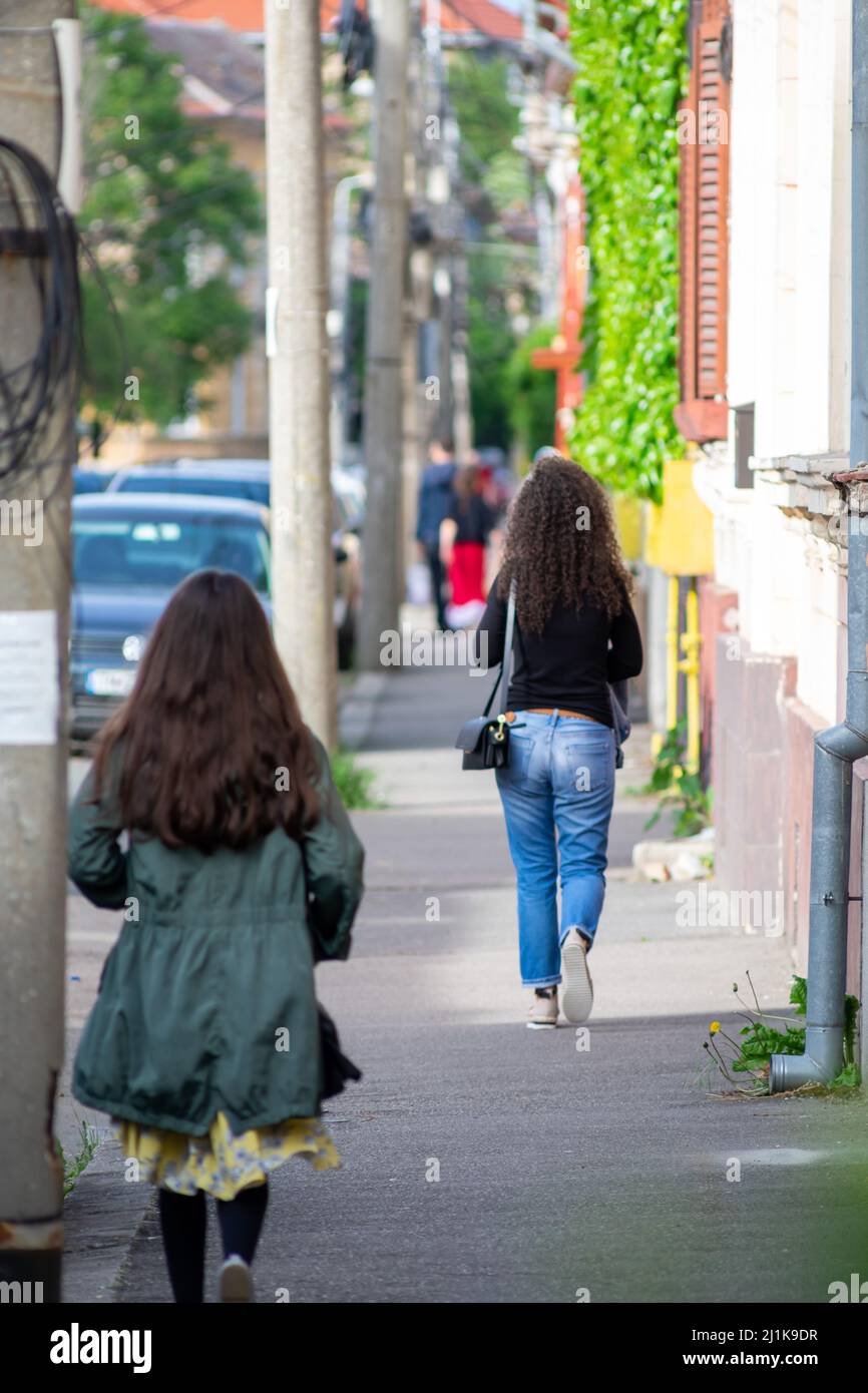 Woman walking on the street. View from behind. Real people Stock Photo ...
