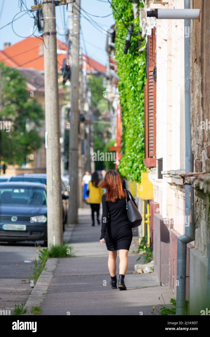 Woman walking on the street. View from behind. Real people Stock Photo ...