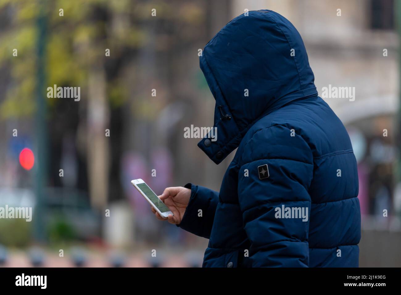 Man walking and checking his phone on the street. Real people Stock ...
