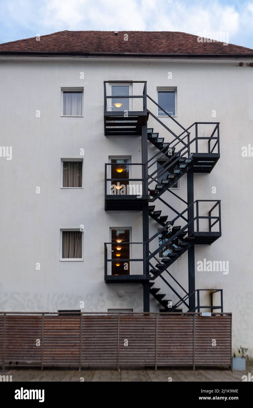 Black fire escape stairs on a white building Stock Photo - Alamy