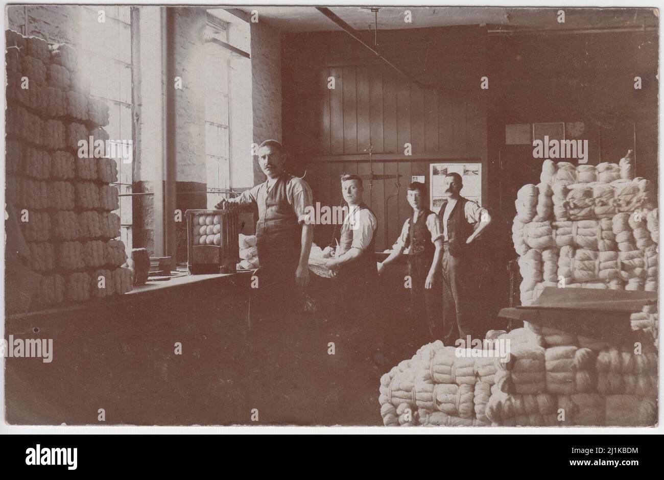 Textile mill warehouse: 3 men and a boy standing next to a large ...
