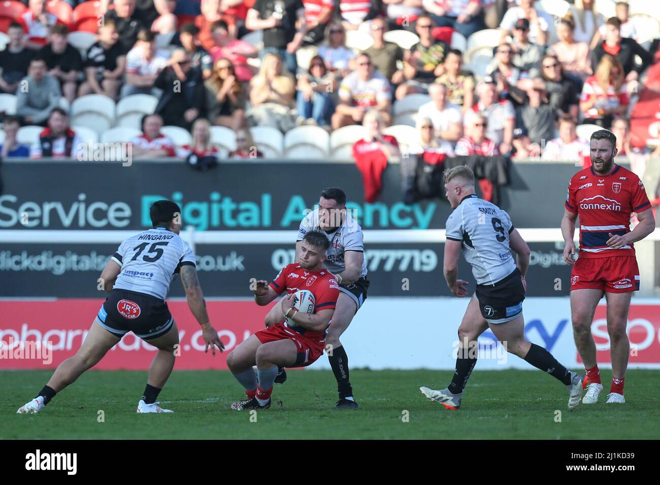 Mikey Lewis #20 of Hull KR is dragged back by Joe Wardle #11 of Leigh ...