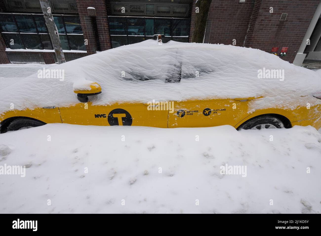 Snow wraps up a yellow taxi on the street at East Village NYC Stock ...