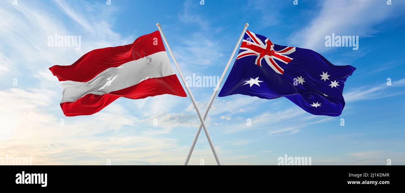 two crossed flags Austria and Australia waving in wind at cloudy sky ...