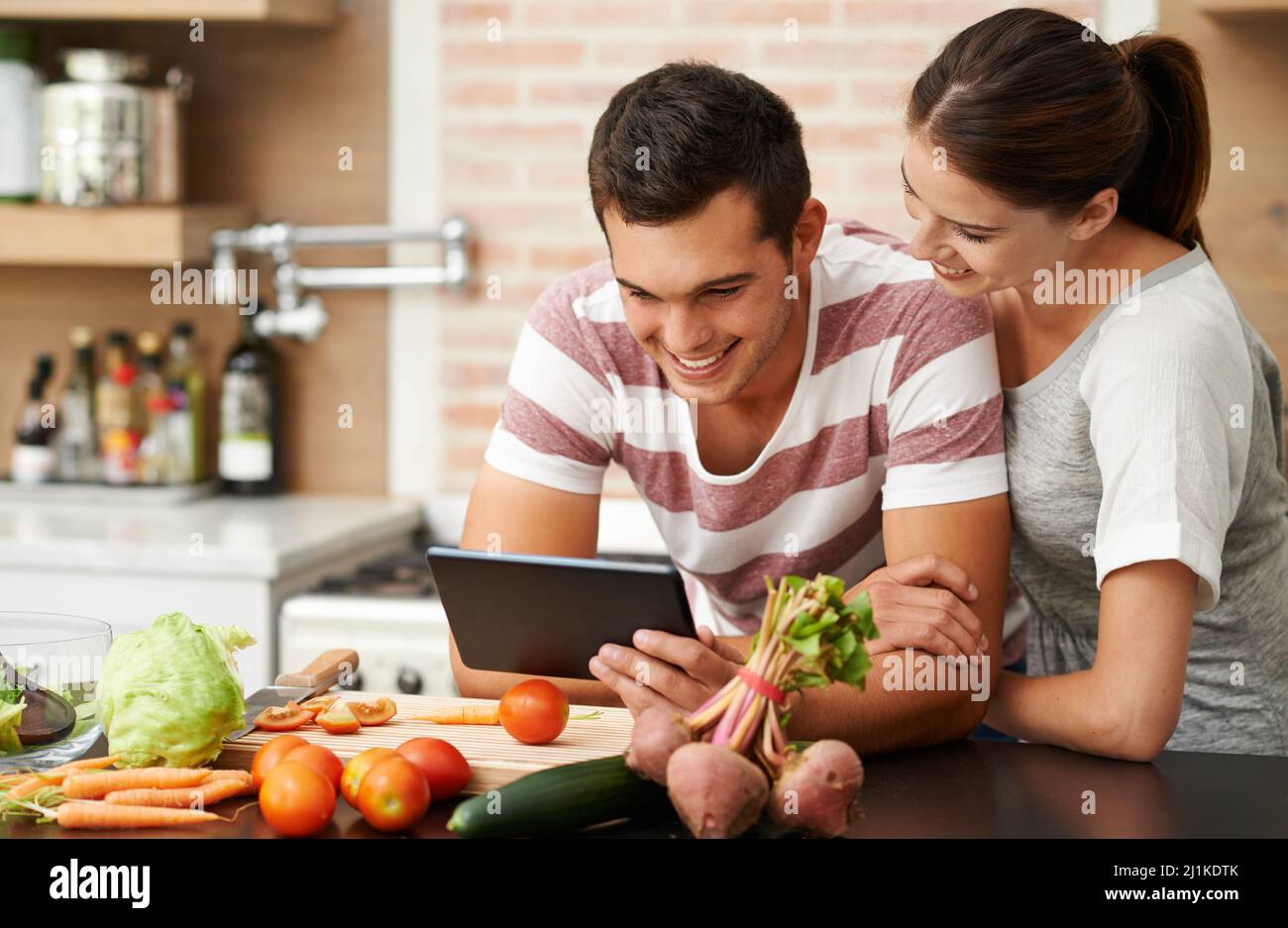Choosing the perfect recipe together. Shot of an attractive young ...
