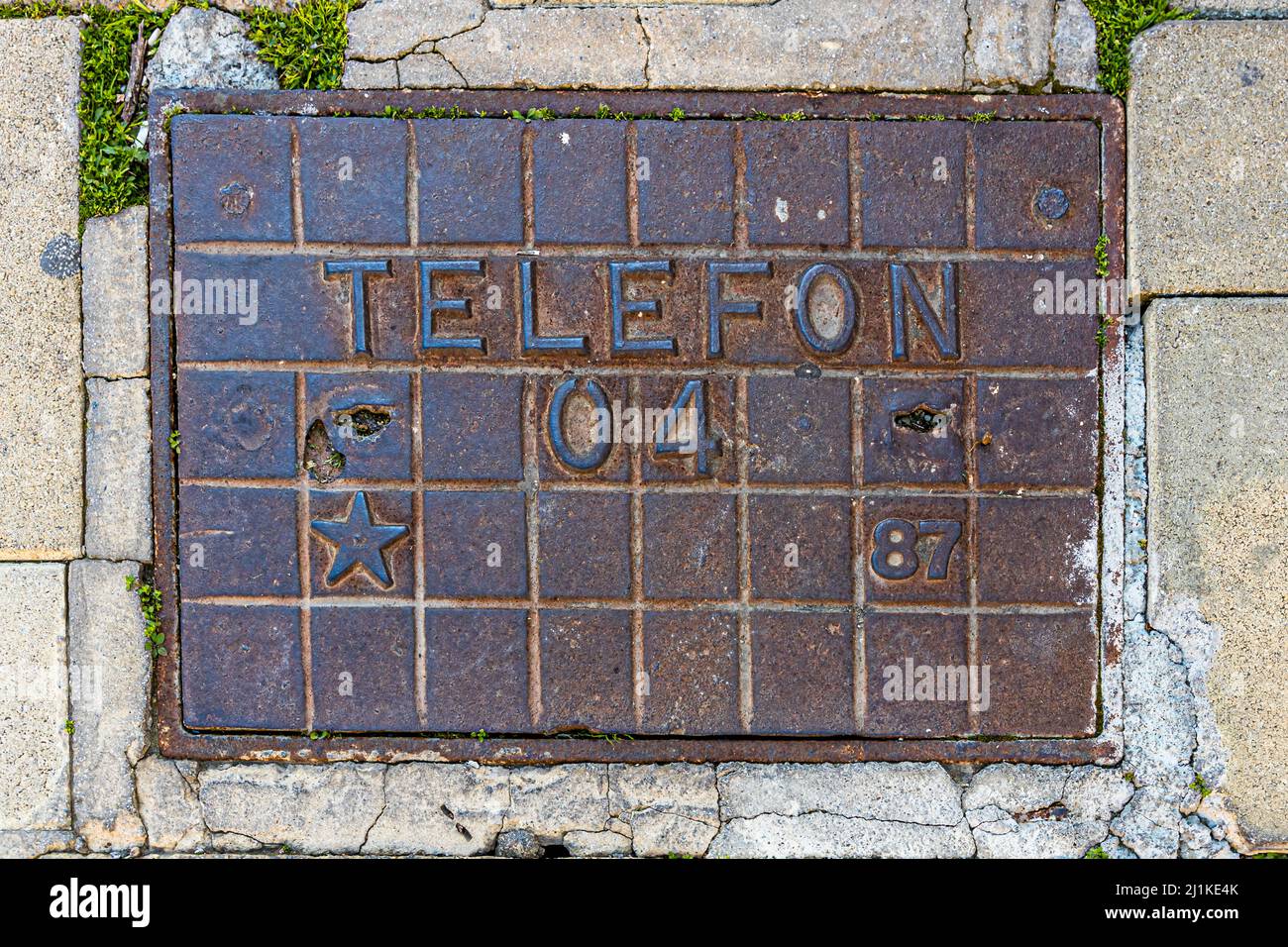 Metal cover of a telephone line lying under the sidewalk in Gazimağusa ...