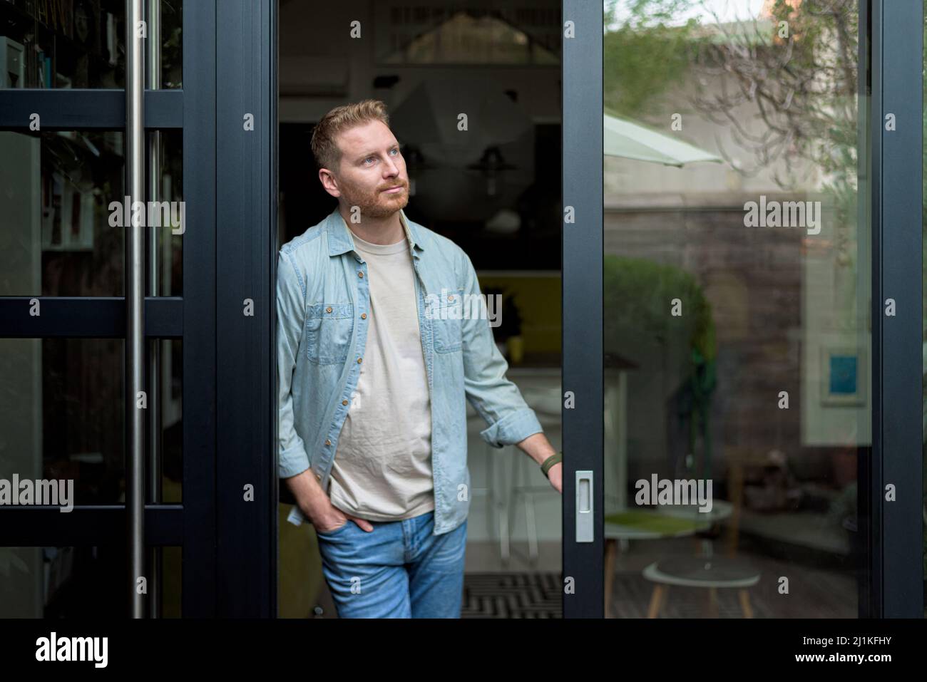 Serious caucasian man, checking the weather outside Stock Photo - Alamy
