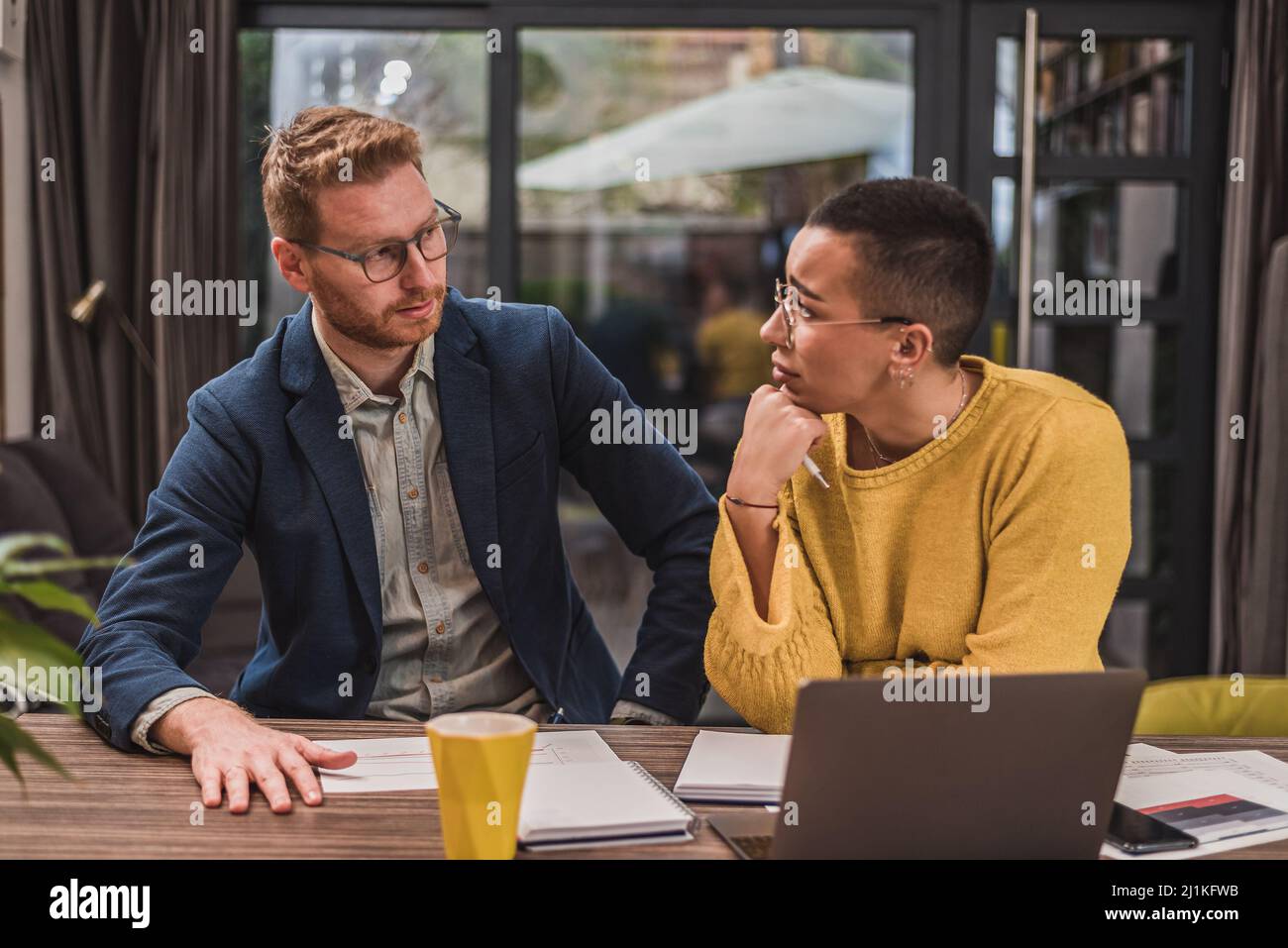 Helpful beaded man, giving professional advice to his female coworker ...