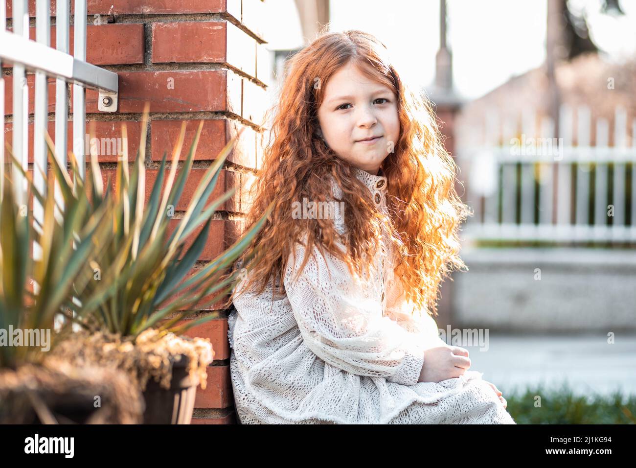 Portrait of a cute, little, ginger girl in white dress Stock Photo - Alamy