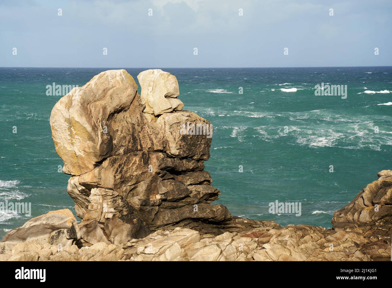 Rock at the water's edge from the french coast. Cloudy sky over blue ...