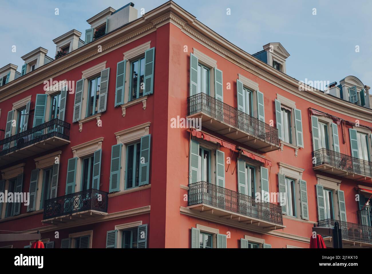 View of a traditional pastel coloured building with balconies in Nice ...