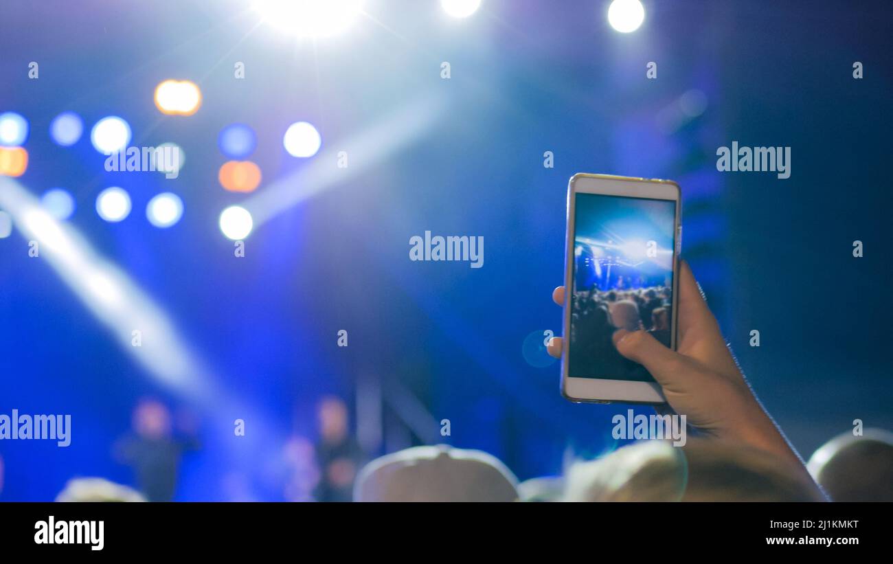 Man hands silhouette recording video of live music concert with ...