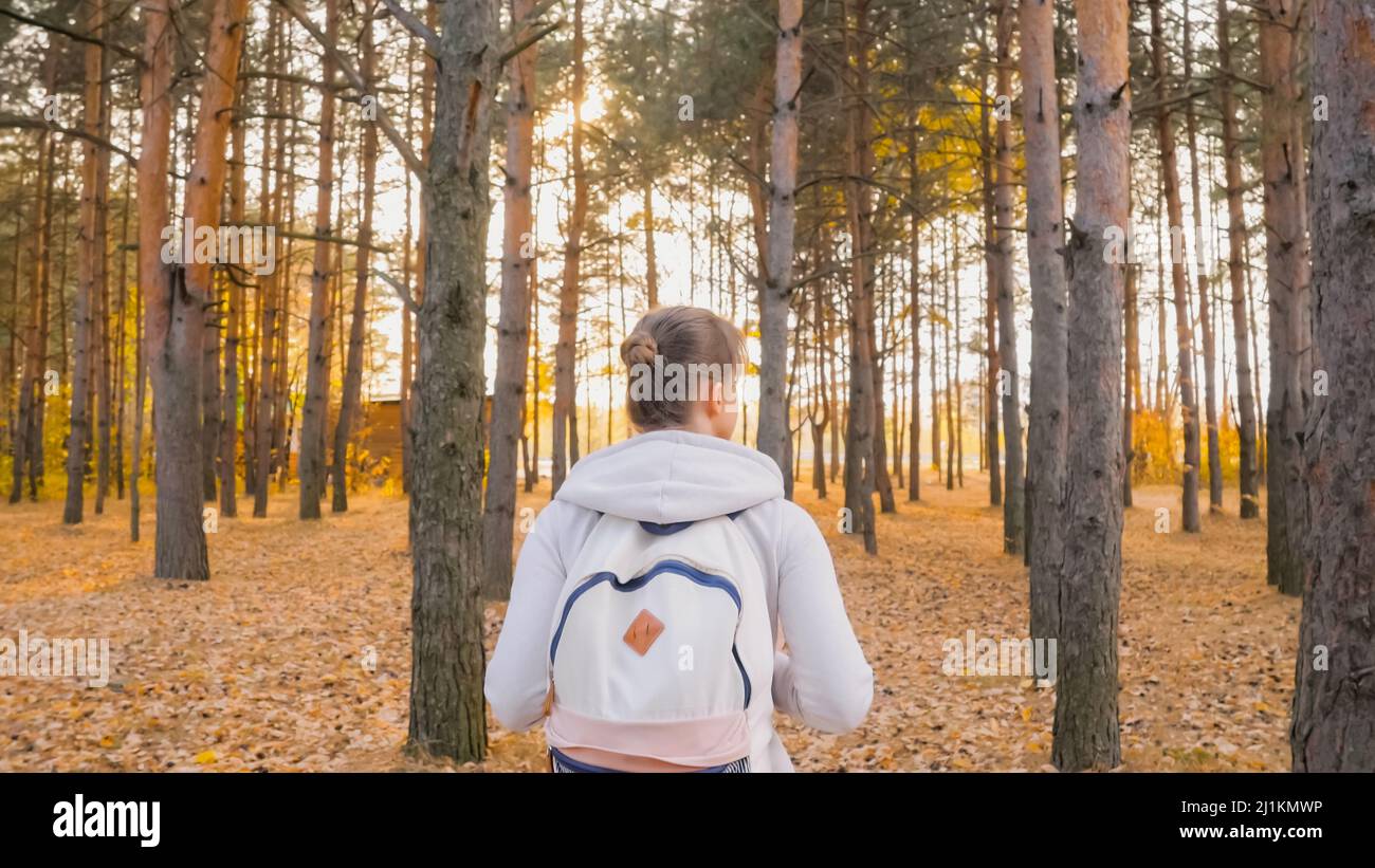 Back view of young woman with backpack walking in autumn park Stock ...