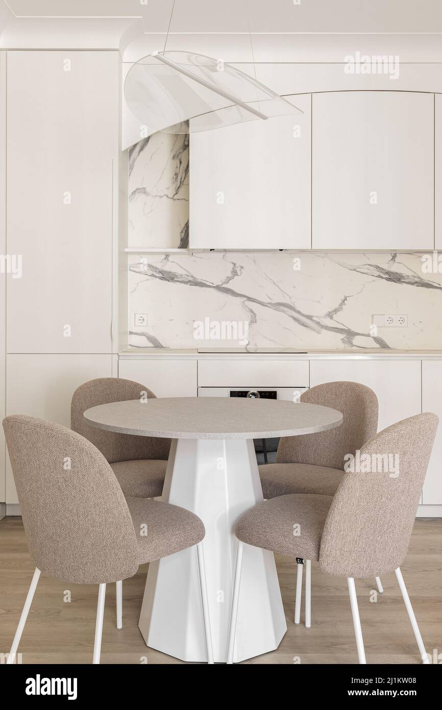 Modern living room interior in pastel colours with round dining table ...