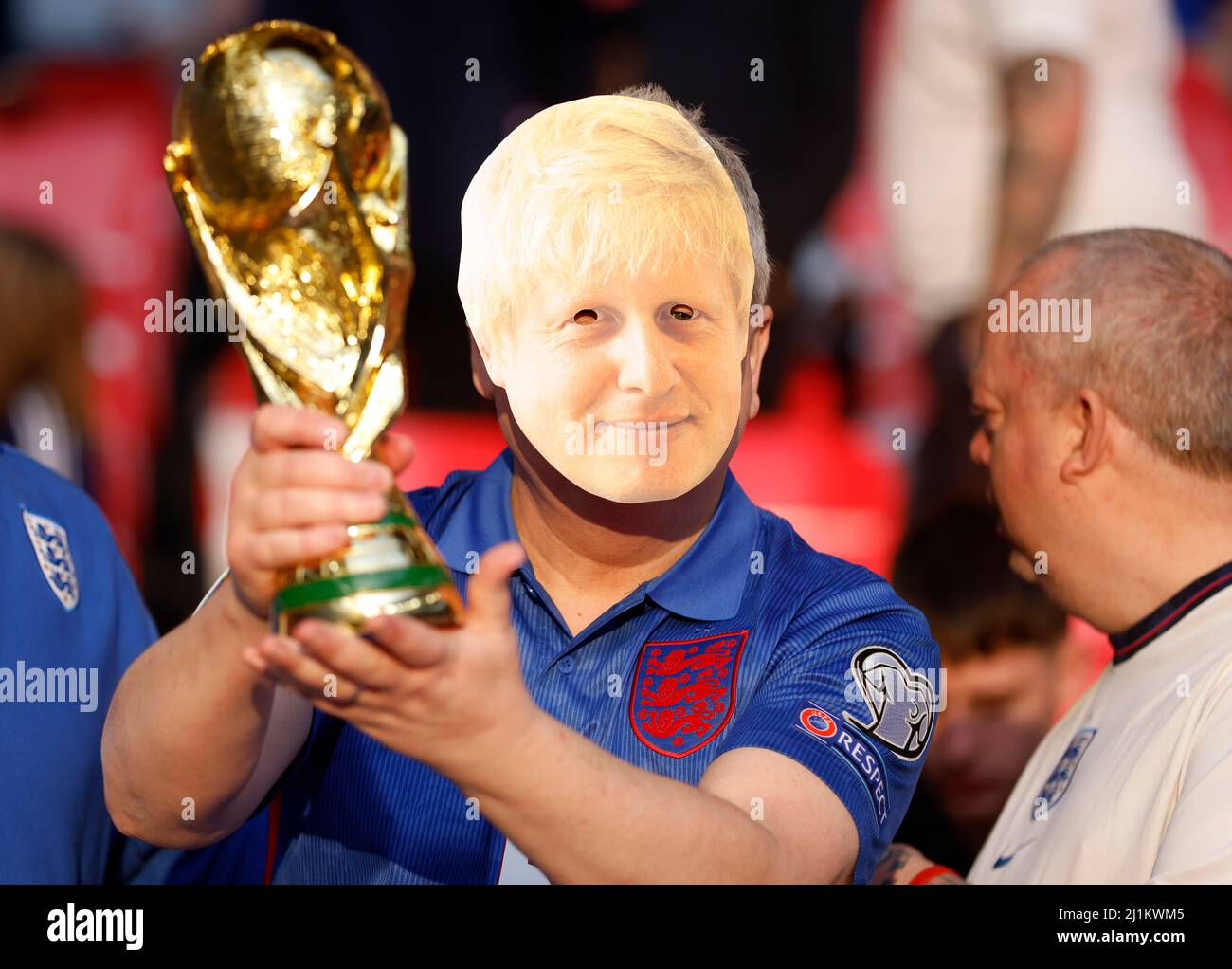 An England fan wearing a Boris Johnson mask with a replica of the FIFA ...