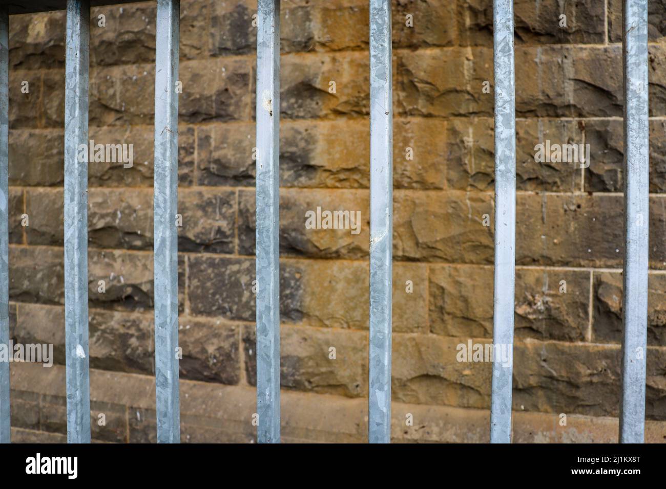 A steel fence and bluestone wall background Stock Photo - Alamy